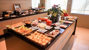 Buffet com diversos pratos e uma planta em vaso.