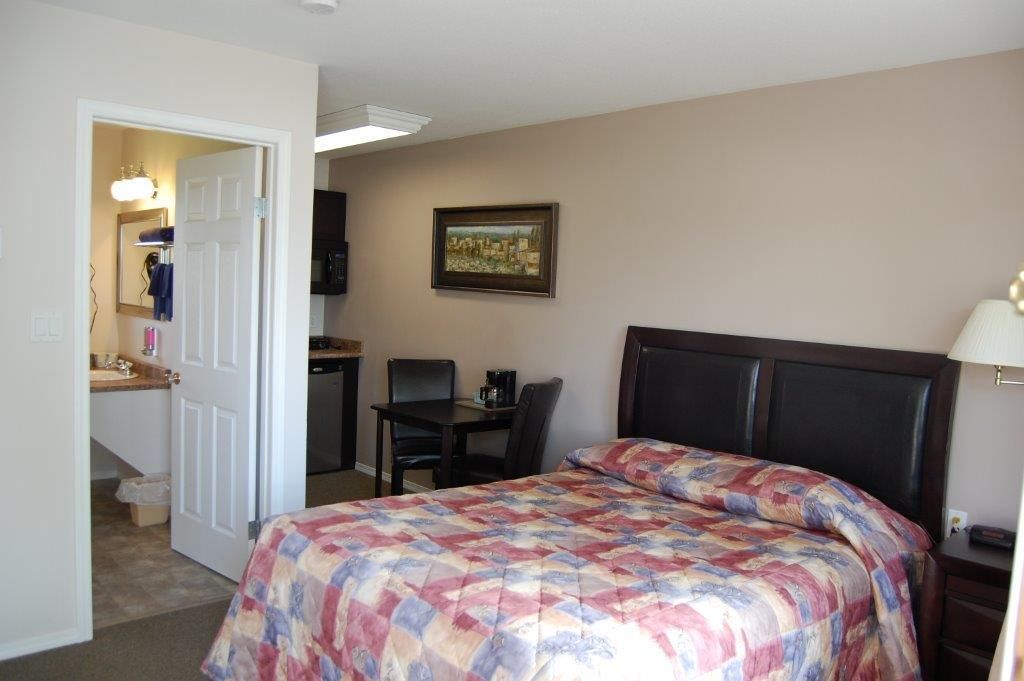 Quarto com cama, escrivaninha e cadeira.