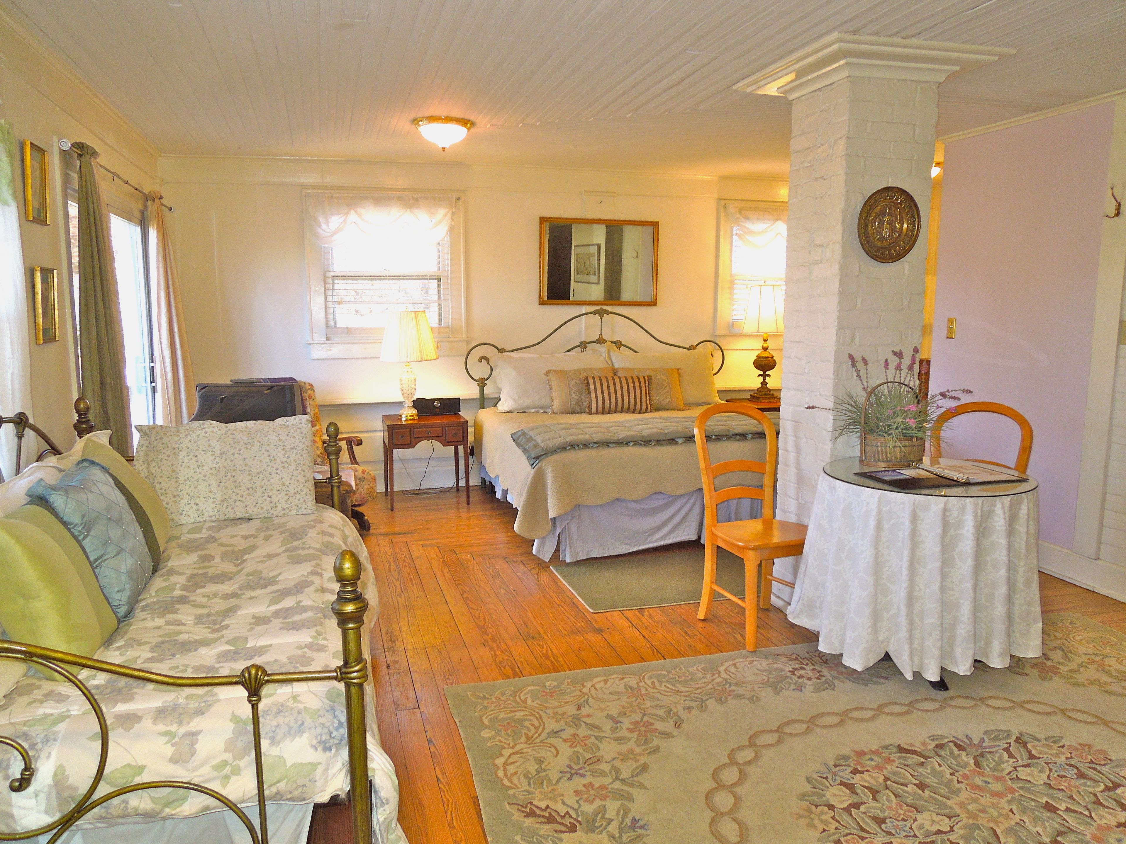 Quarto com cama, cadeira, mesa e abajur.