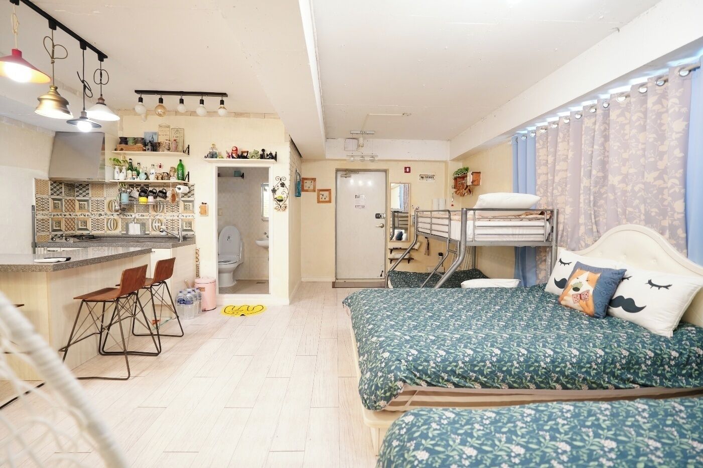 Quarto compacto com beliche, cozinha compacta e banheiro pequeno.