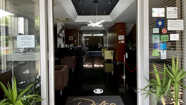 Entrada do Hotel Dolce International, com balcão de recepção, área de estar e vista clara do interior.