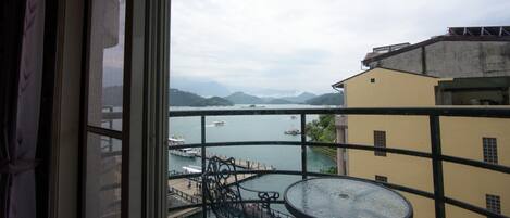 Uma varanda com vista para um porto, uma mesa e uma cadeira.