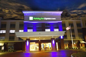 Edifício Holiday Inn Express & Suites com placa visível, diversas janelas e uma bandeira americana.