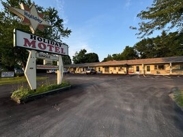Placa Holiday Motel com um edifício térreo ao fundo.