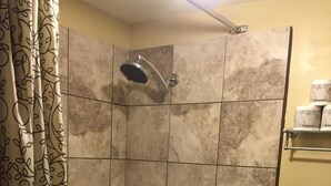 Um banheiro com chuveiro, banheira e vaso sanitário.
