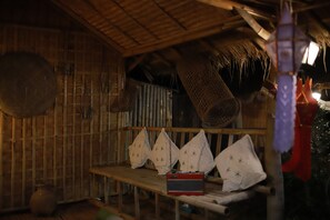 Um interior rústico de madeira com um banco, cestos de palha e um rádio.