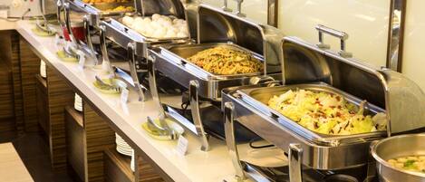 Buffet com diversas opções de comida, incluindo ovos, saladas e outros pratos.