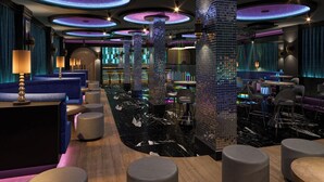 Um interior moderno com luminárias de teto circulares, um espaço de bar e assentos.