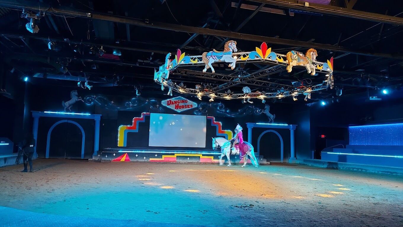 Um palco com tema de circo, apresentando um carrossel e artistas.