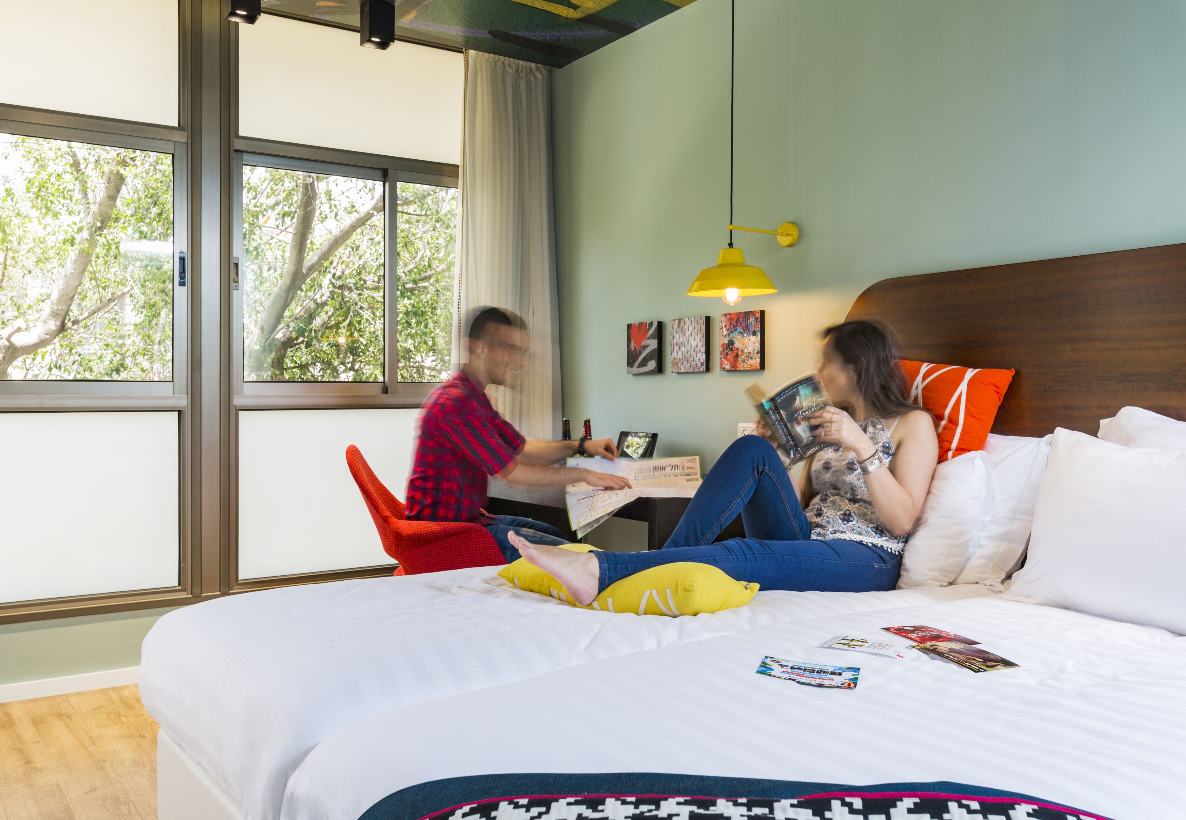 Quarto com cama, janela e abajur amarelo.