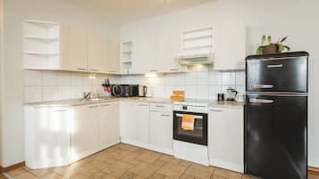 Apartamento superior, 1 quarto | Cozinha privada | Geladeira grande, micro-ondas (mediante solicitação), fogão, cooktop