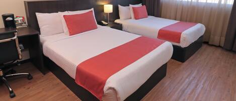 Quarto de hotel com duas camas, uma escrivaninha e uma cadeira.