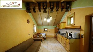 Uma cozinha acolhedora com armários de madeira, uma mesa de jantar e um sofá.