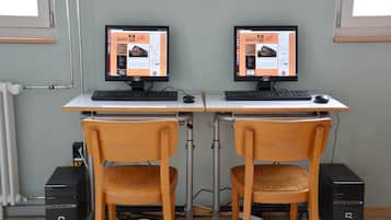 Uma estação de trabalho com dois monitores, duas cadeiras, um radiador e dois computadores de mesa.