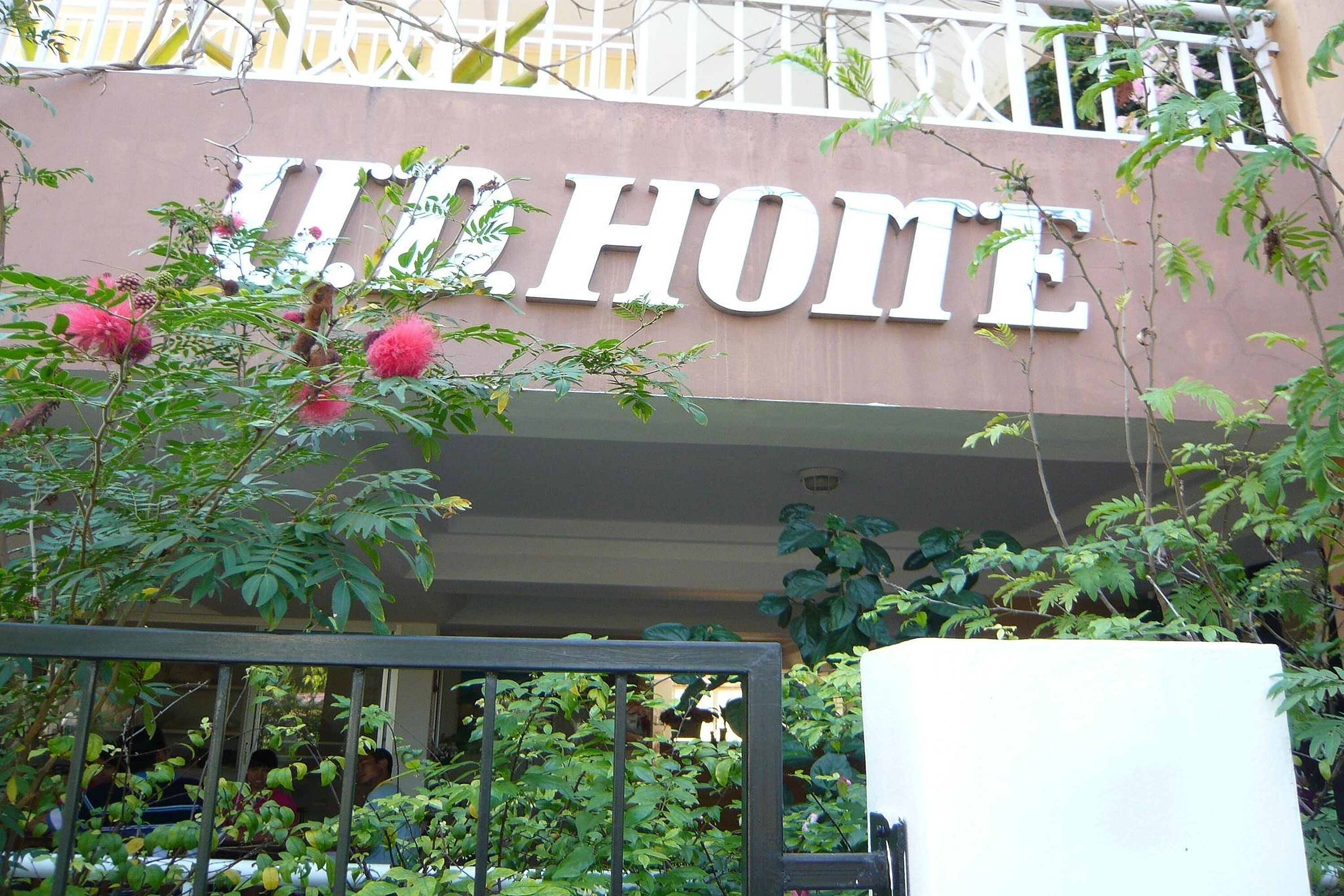 Placa de hotel com o nome 'HOTEL HOME' em letras grandes.