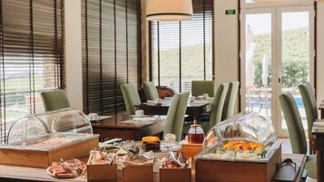 Um buffet de café da manhã com diversos alimentos e vista para o exterior.