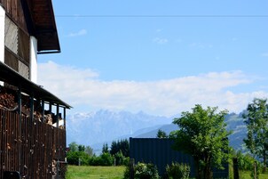 Um edifício rústico com varanda e vista para uma paisagem montanhosa.