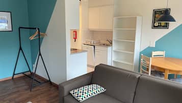 Uma sala de estar moderna com sofá, mesa de jantar e área de cozinha.
