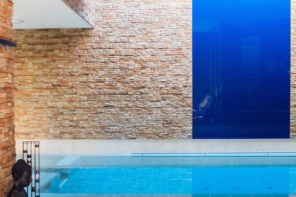 Piscina interior, guarda-sóis, espreguiçadeiras