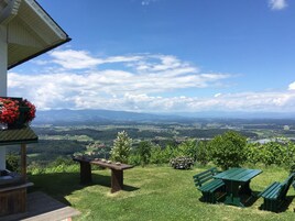 Pátio com mesa e bancos com vista para uma paisagem deslumbrante.