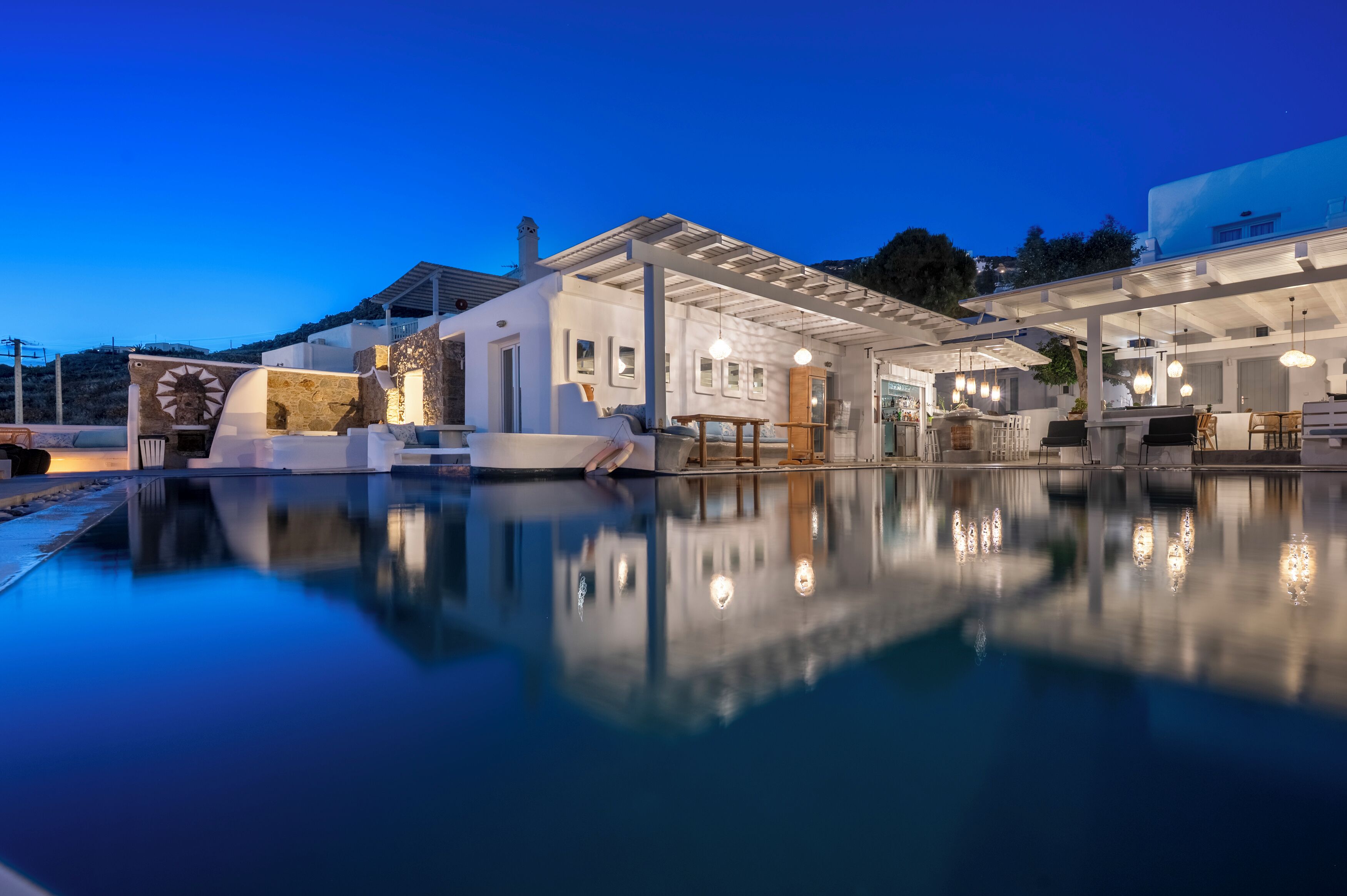Um edifício moderno com piscina, área de estar ao ar livre e um pátio coberto.