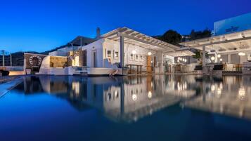 Um edifício moderno com piscina, área de estar ao ar livre e um pátio coberto.