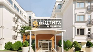 Entrada de um hotel com uma placa que diz "LA QUINTA BY WYNDHAM".