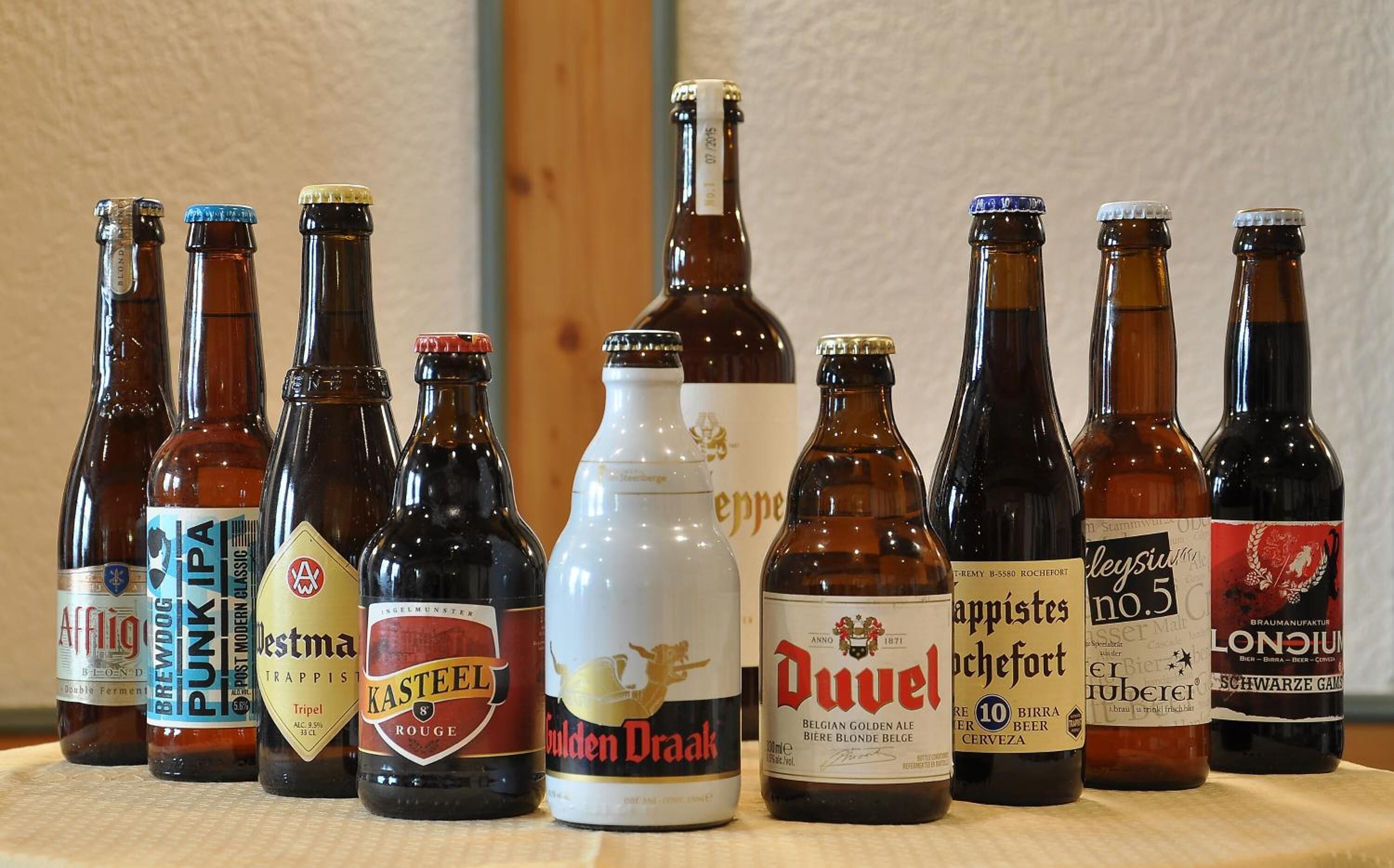 Um conjunto de garrafas de cerveja com diferentes rótulos e desenhos.