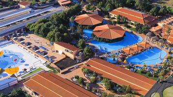 Vista aérea de um resort com várias piscinas, parque aquático e amplo estacionamento.