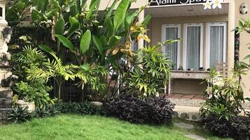 Um spa chamado 'Alami Spa' com um jardim bem cuidado, com diversas plantas e um caminho de pedra.