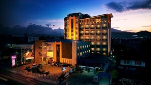 Um hotel com vários andares, área de estacionamento e vista para a paisagem circundante.