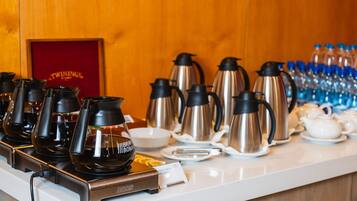 Uma estação de café com várias máquinas de café e uma caixa de café da marca.