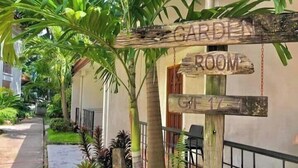 Placa de madeira com a inscrição 'GARDEN ROOM', indicando a área do jardim.