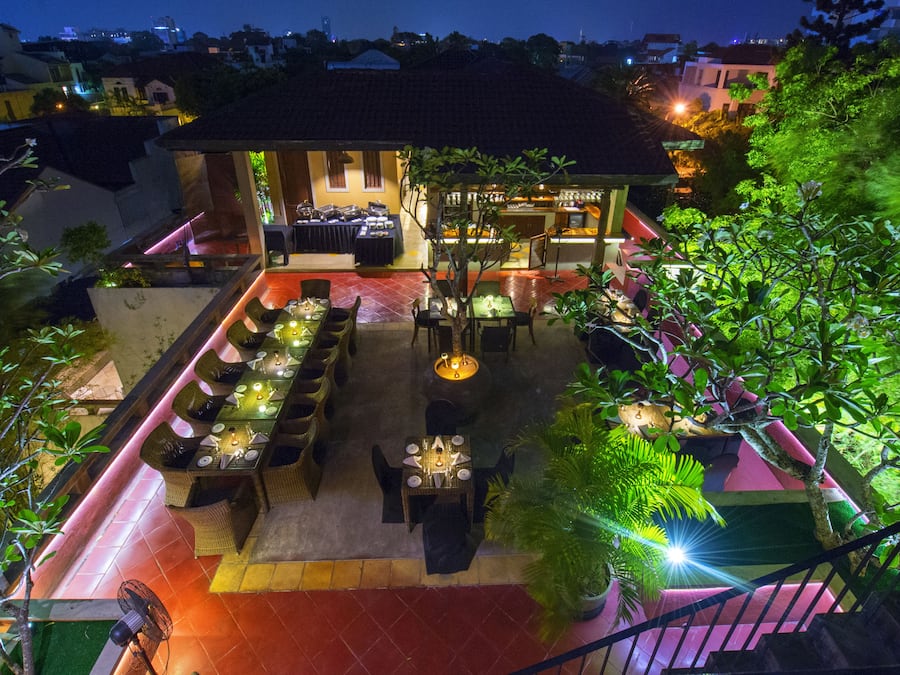 Um restaurante no terraço com área externa, um bar e uma escadaria que leva ao andar superior.