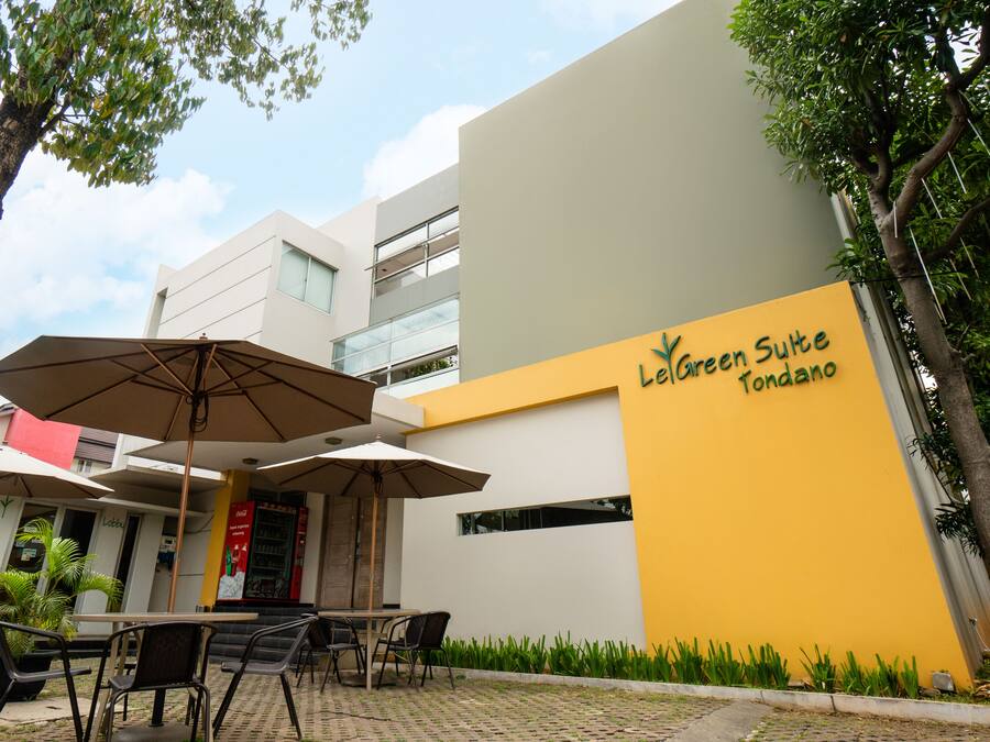 Um edifício com fachada amarela e uma placa com a inscrição 'LeLeGreen Suite Fonda'.