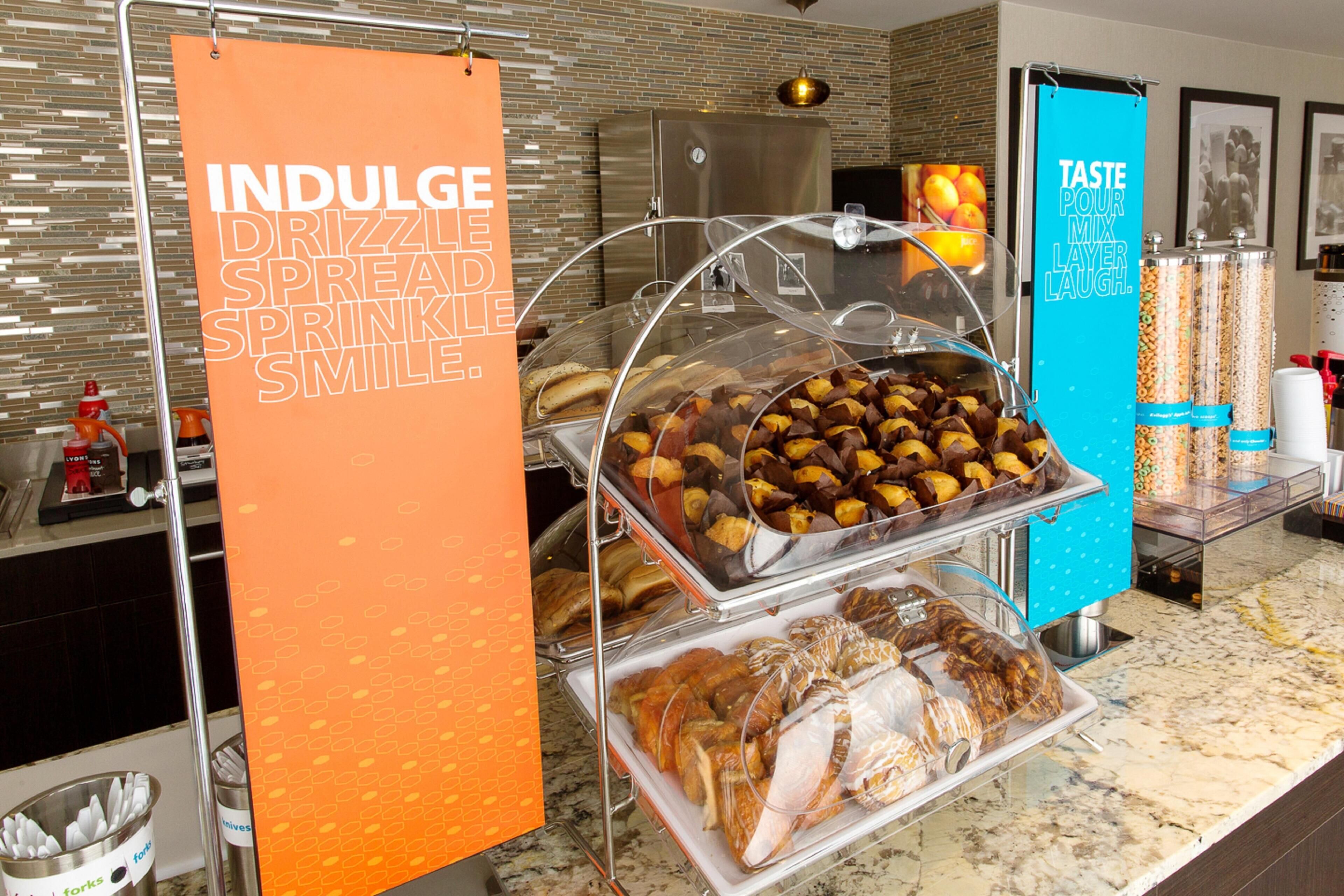 Um buffet com uma placa que diz 'INDULGE DRIZZLE SPREAD SMILE'.
