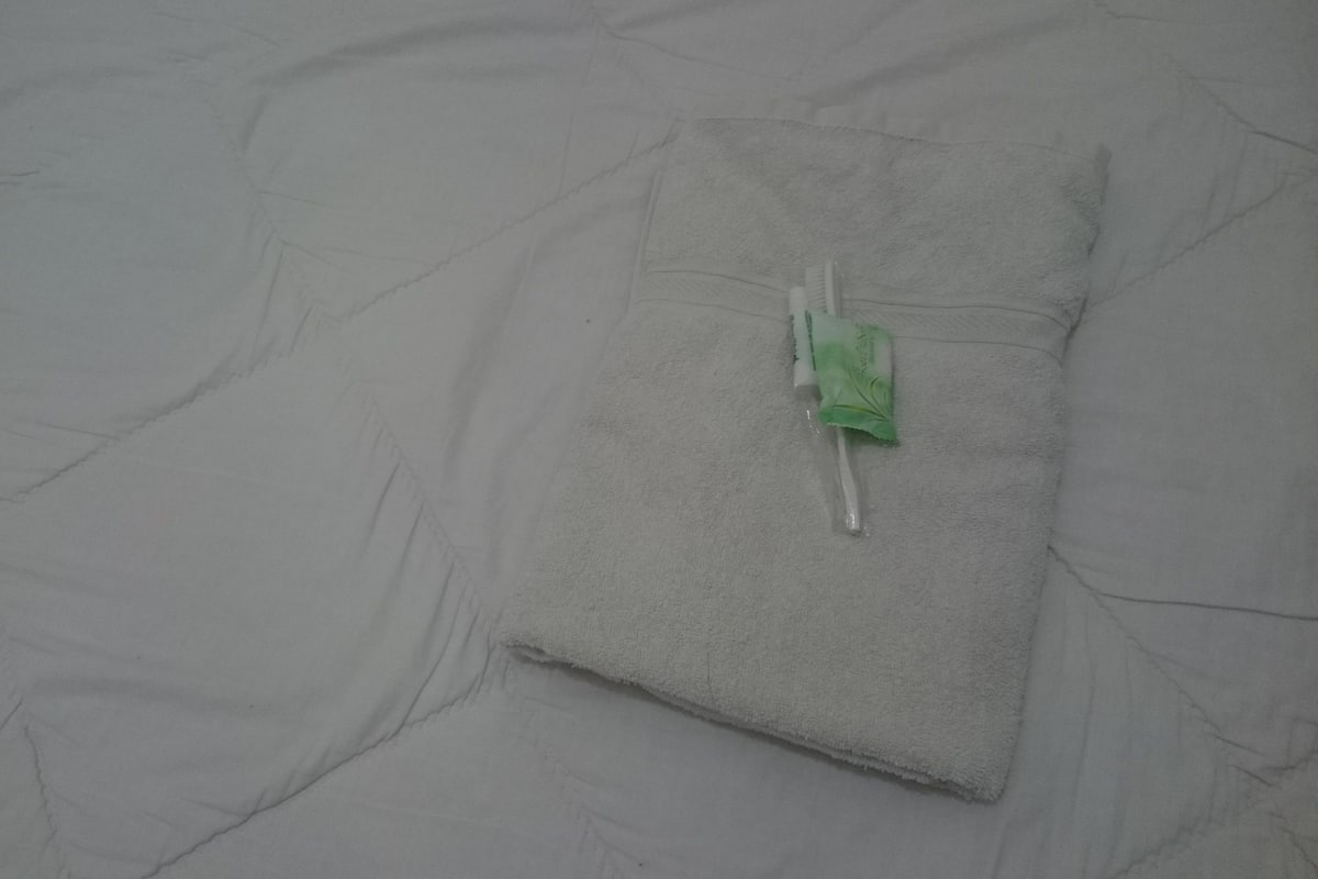 Superfície branca e texturizada com um objeto verde e um objeto branco.