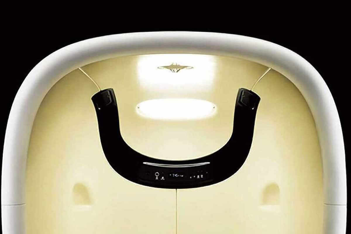 Quarto moderno e minimalista com parede branca curva, estrutura preta central e um único travesseiro branco.