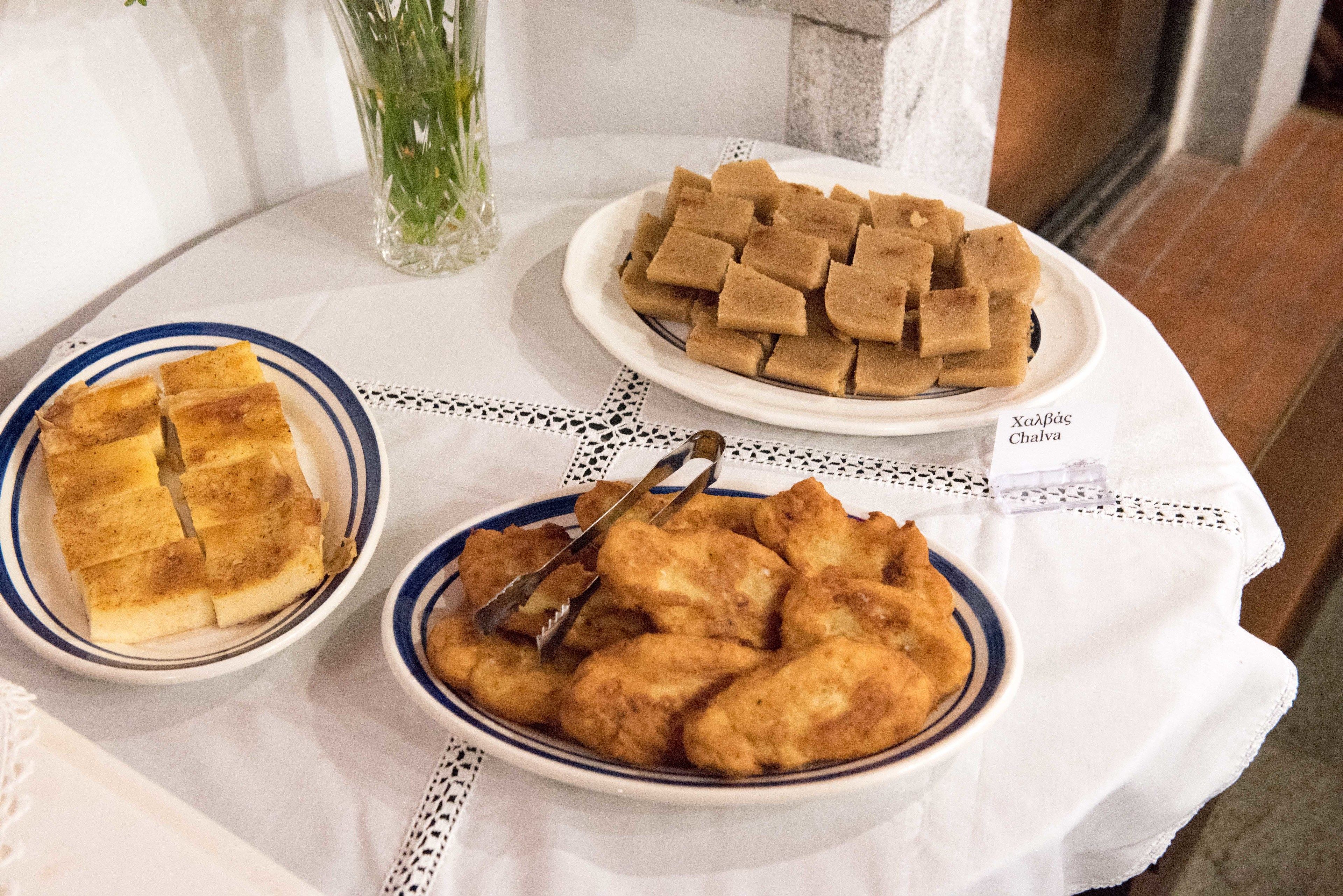 Uma mesa com três pratos: uma tigela de alimentos fritos, um prato de quadrados fritos e um prato de cubos fritos.