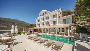 Um hotel com piscina, área de estar ao ar livre e vista para as montanhas.