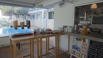 Uma área de bar com balcão de madeira, um piano e um letreiro listando bebidas e coquetéis.