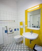 Casa de banho com sanita, lavatório e espelho.
