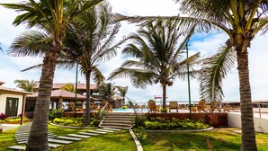 Um resort com palmeiras, piscina e um jardim bem cuidado.