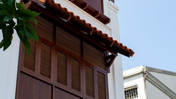 Um edifício tradicional com várias janelas de madeira e telhado telhado.