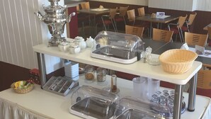 Disposição de buffet com bandejas, potes e um jarro de prata decorativo.