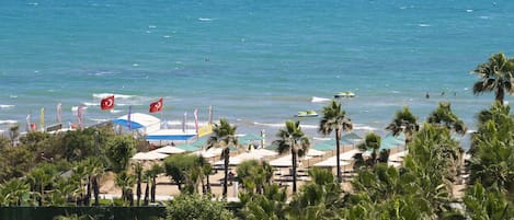 Na praia, espreguiçadeiras, guarda-sóis de praia, toalhas de praia
