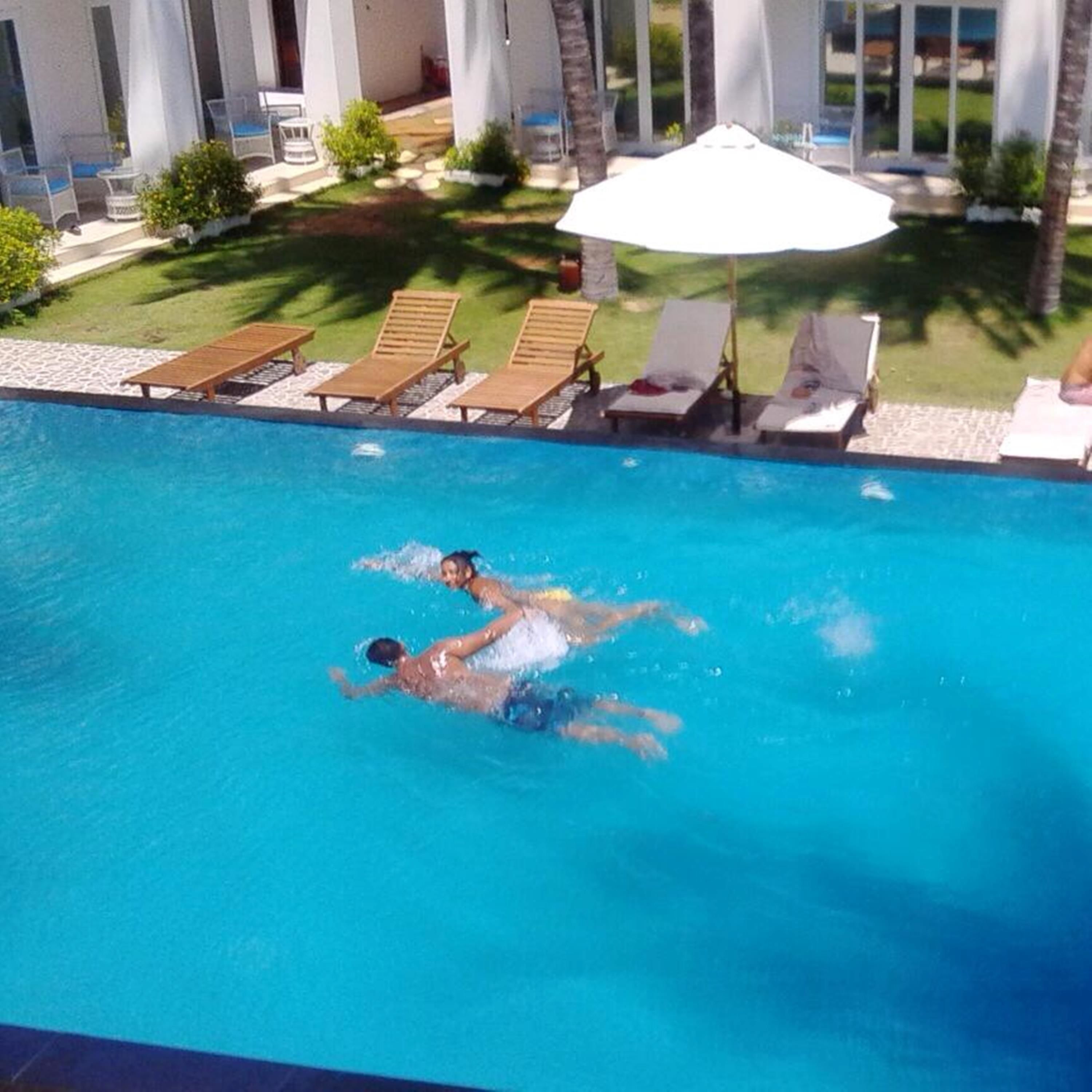 Uma piscina com espreguiçadeiras e guarda-sóis.