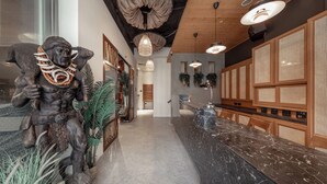 Cozinha moderna com bancada de mármore, armários de madeira e iluminação pendente.