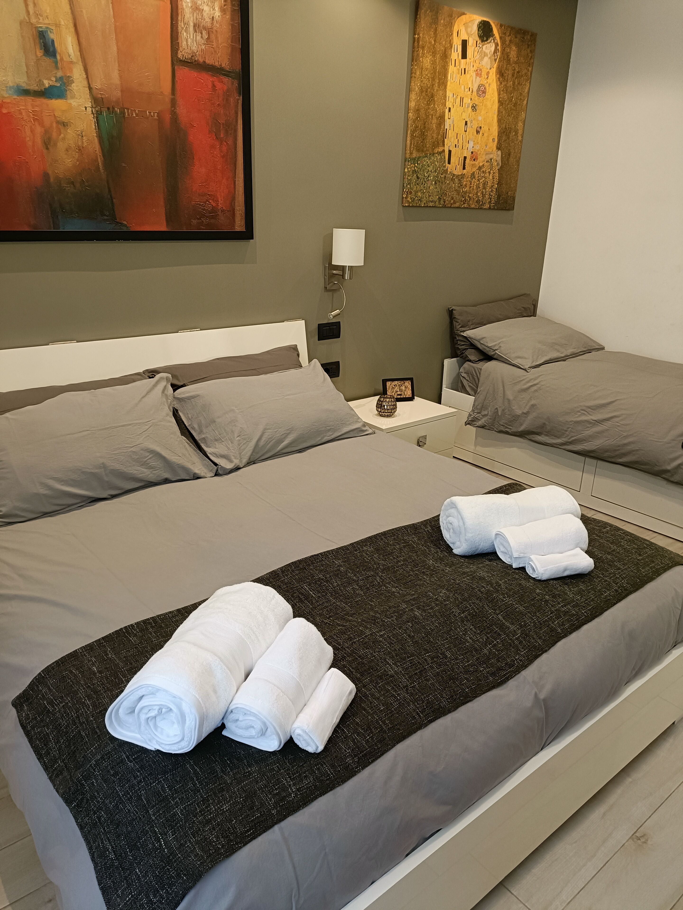 Quarto de hotel com uma cama grande, duas mesas de cabeceira e um quadro na parede.
