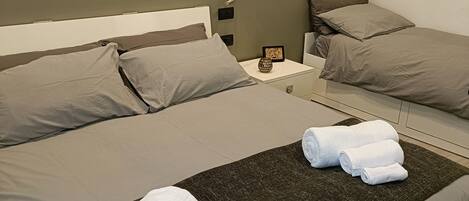 Quarto de hotel com uma cama grande, duas mesas de cabeceira e um quadro na parede.